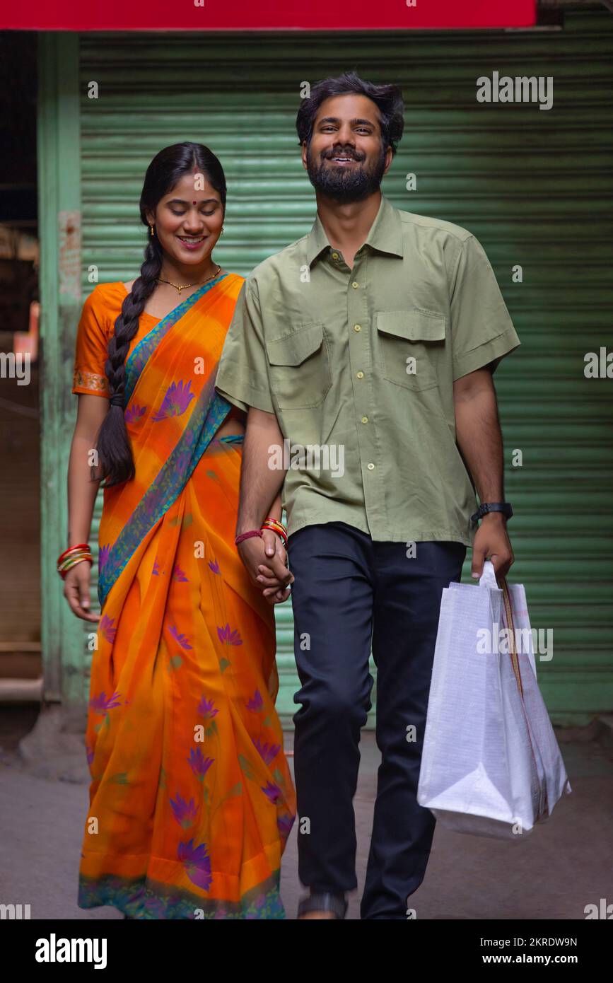 Portrait of young couple together walking on footpath Stock Photo - Alamy