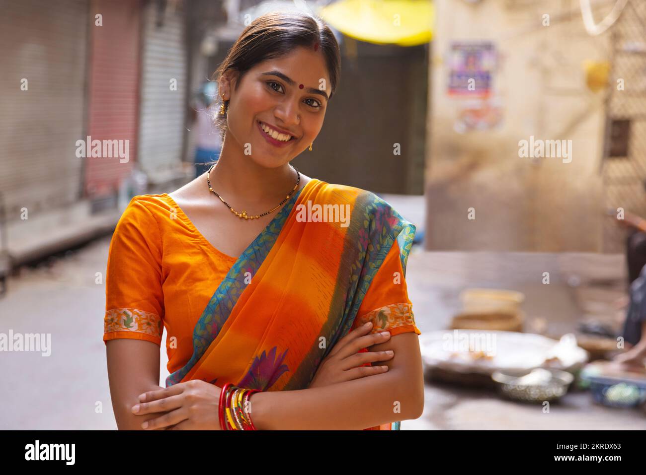 Portrait of smiling woman in saree standing on street Stock Photo - Alamy