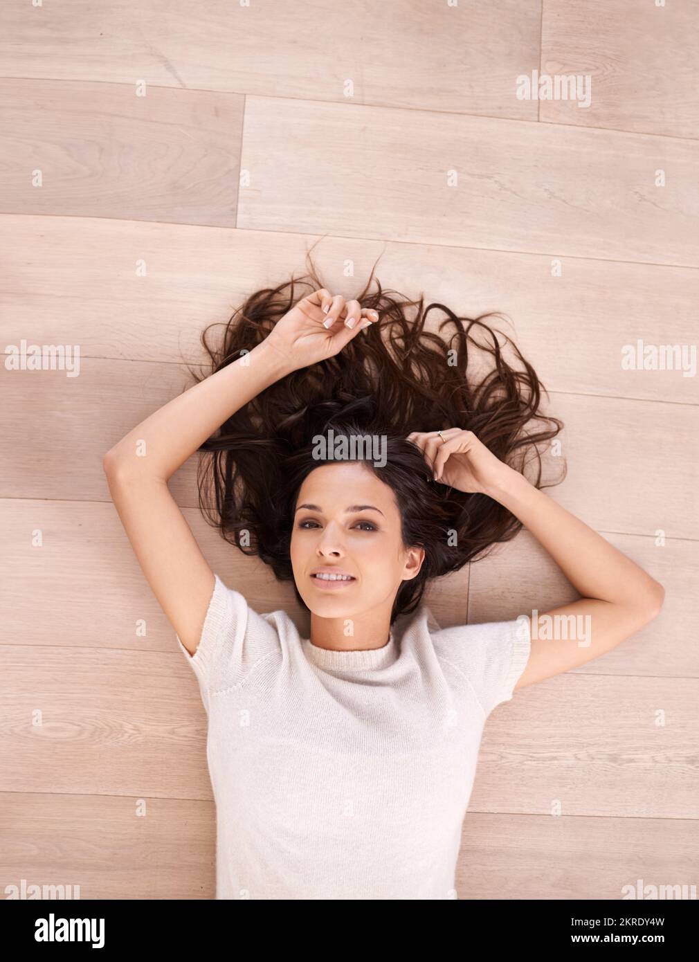 Looking natural and relaxed. A young woman smiling at the camera as she ...