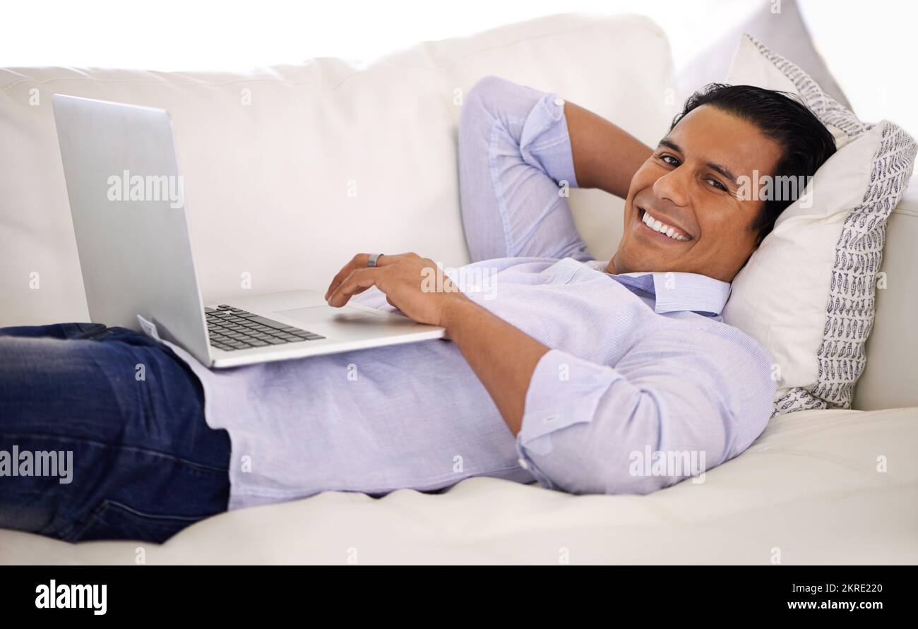 Technology at home. A handsome young man using his laptop at home Stock ...