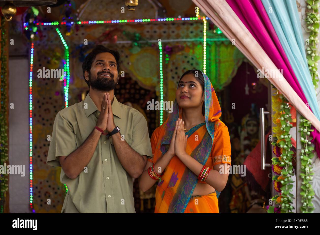 Portrait of young couple praying together at temple Stock Photo - Alamy