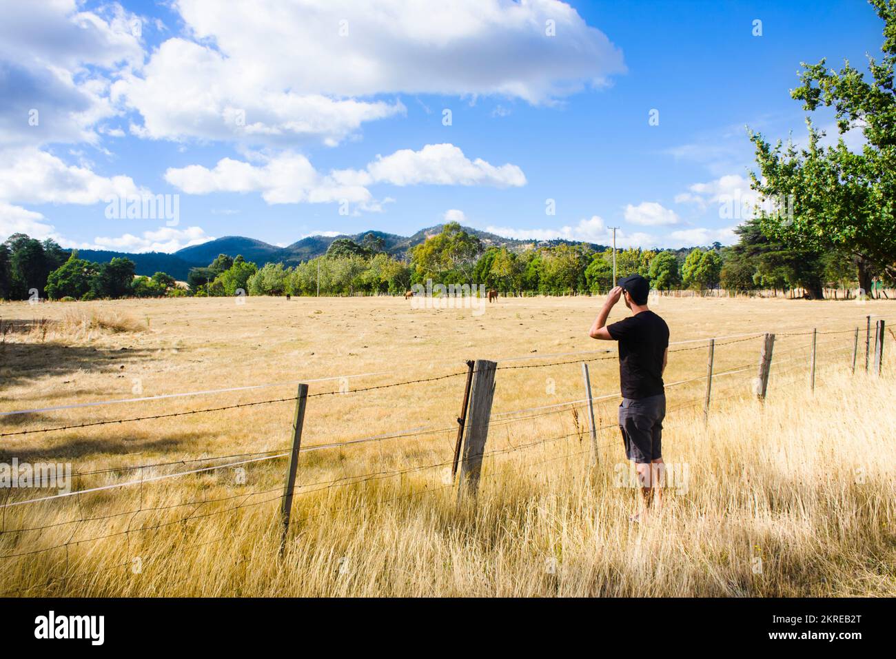 Horizontal photograph of a male tourist standing in long sun-bleached ...