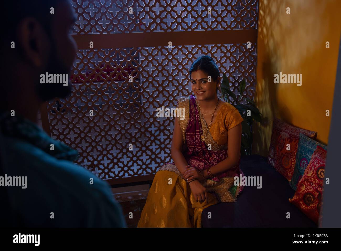 Portrait of smiling married Gujrati woman sitting on deewan and looking ...