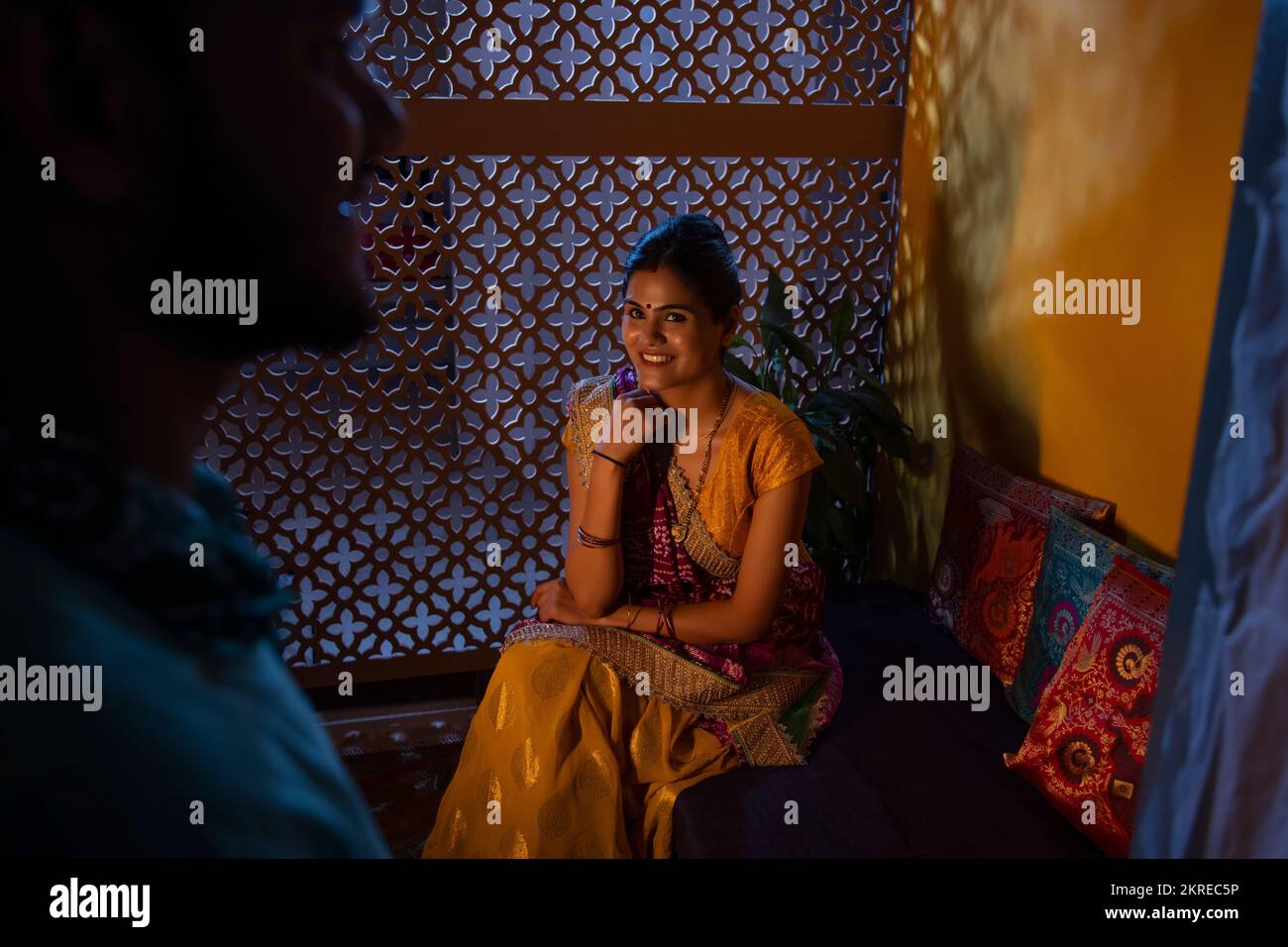 Portrait of smiling married Gujrati woman sitting on deewan and looking ...