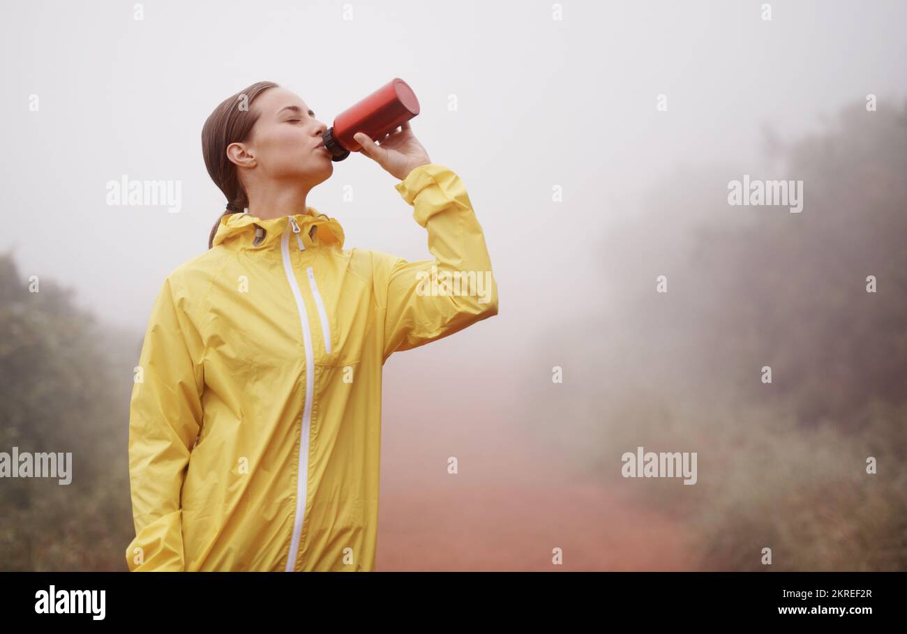 A drink along the way. A young female runner drinking from her water ...