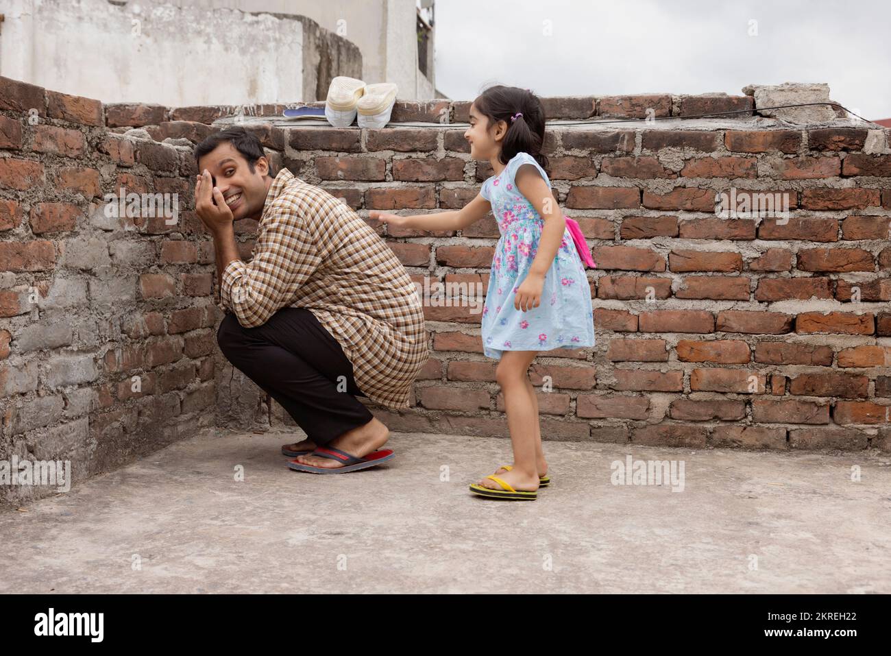 Father playing hide and seek with his daughter in the backyard Stock ...