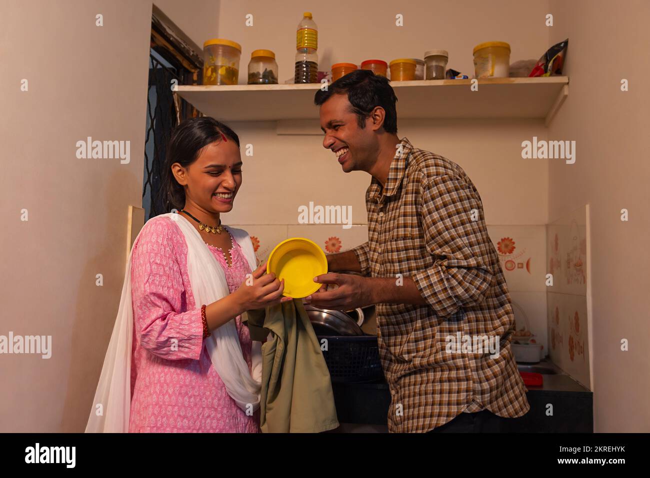 Husband helping his wife with housework in the kitchen Stock Photo - Alamy