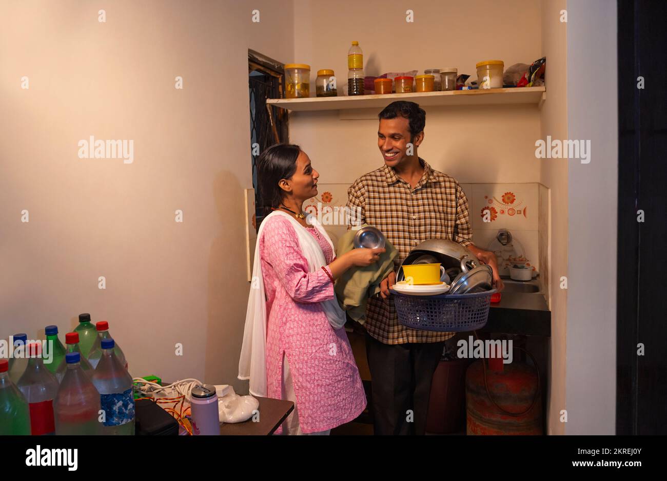 Husband helping his wife with housework in the kitchen Stock Photo - Alamy
