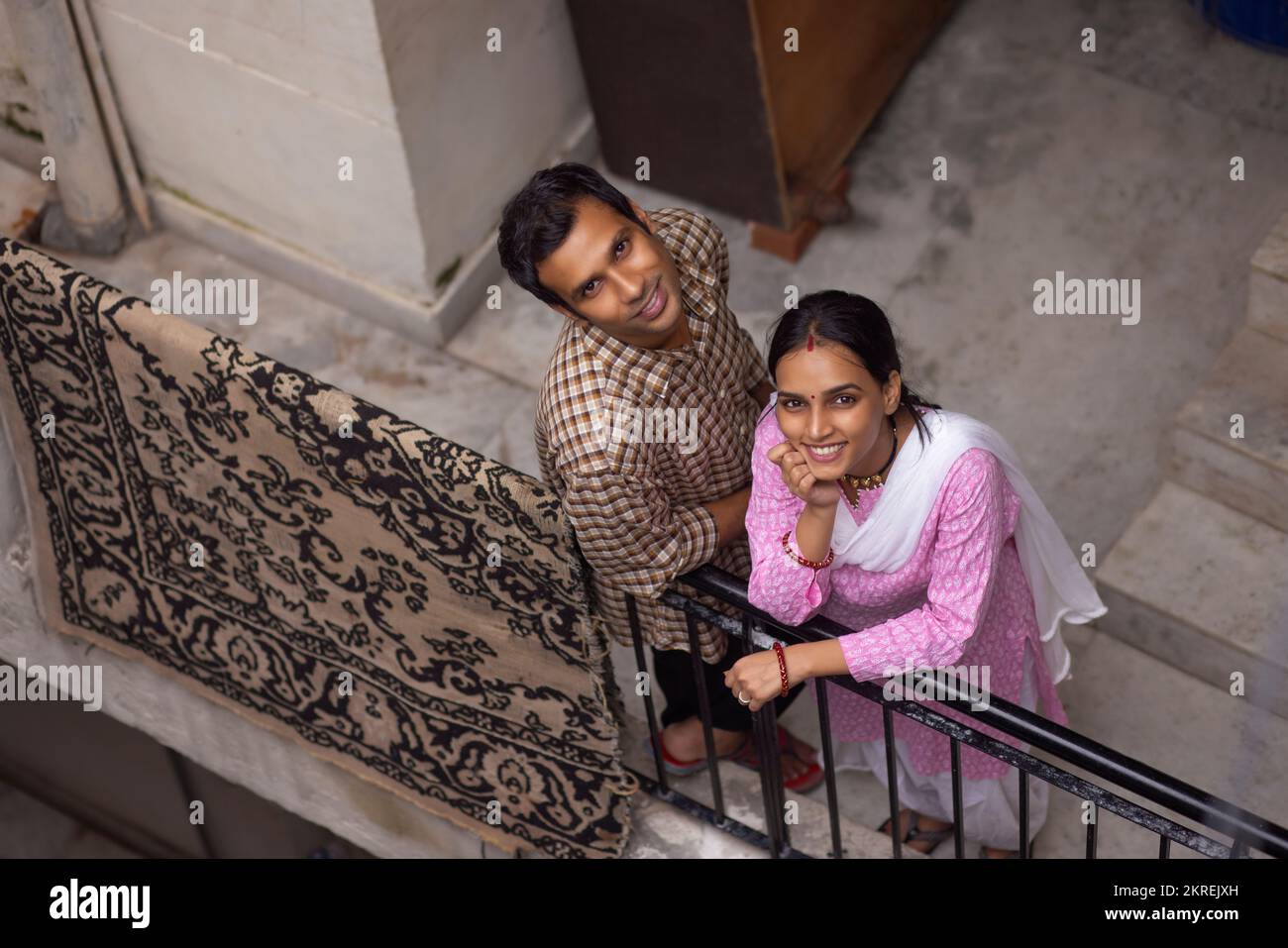 Overhead view of young couple standing in balcony Stock Photo - Alamy