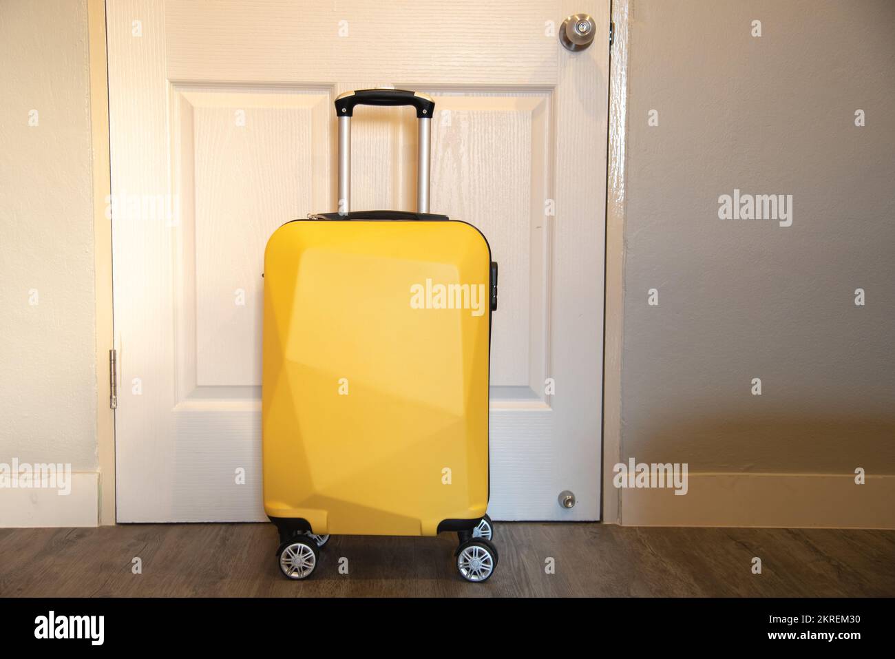 Yellow travel suitcase in the bedroom on the door background - relaxing ...