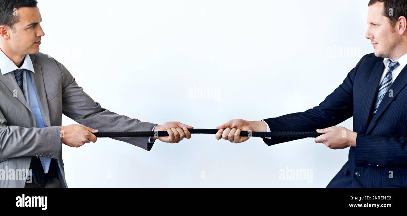 Im determined to beat you. Cropped studio shot of two men pulling on ...