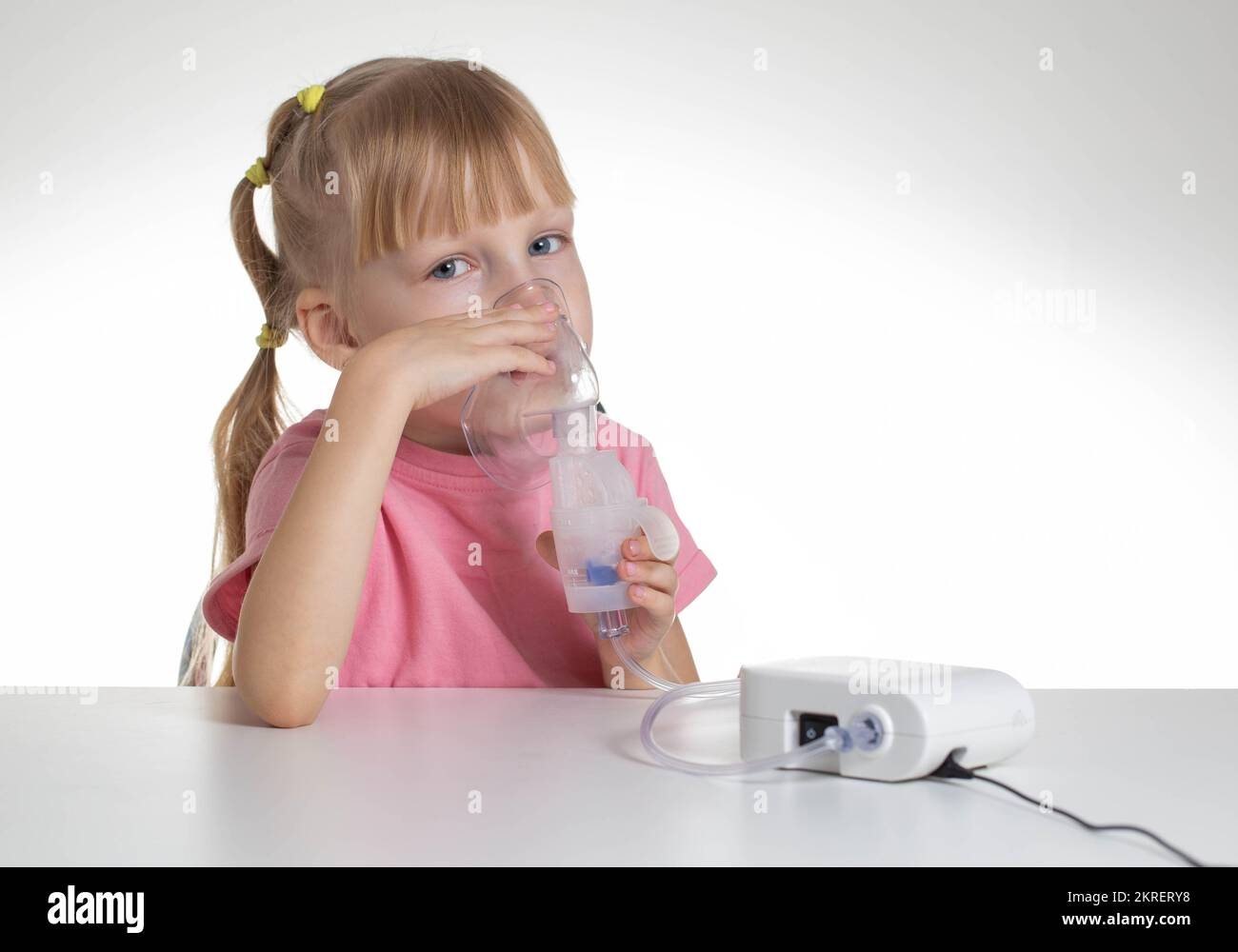 Beautiful little girl breathing into an inhaler for asthma and ...