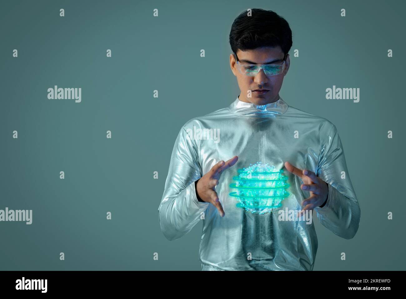 A man wearing silver, futuristic clothes holding digital globe , future ...