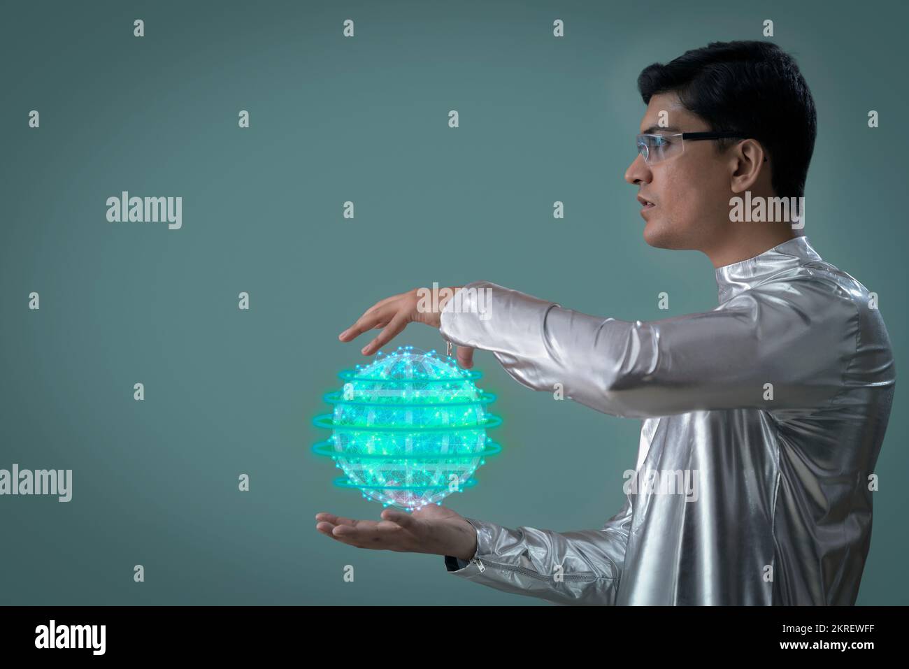 A man wearing silver, futuristic clothes holding digital globe , future ...