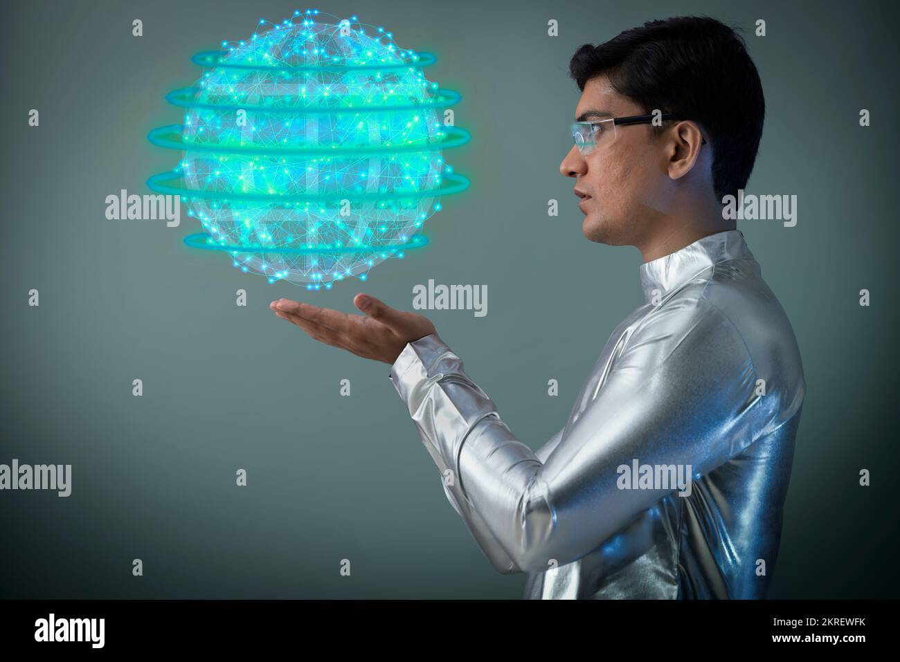A man wearing silver, futuristic clothes holding digital globe , future ...