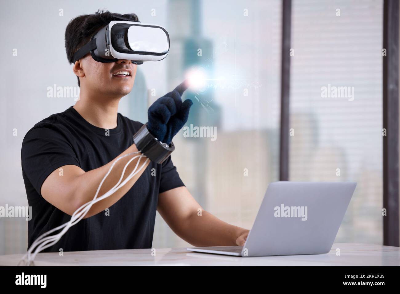 Man wearing VR headset and haptic glove interacting with virtual object ...