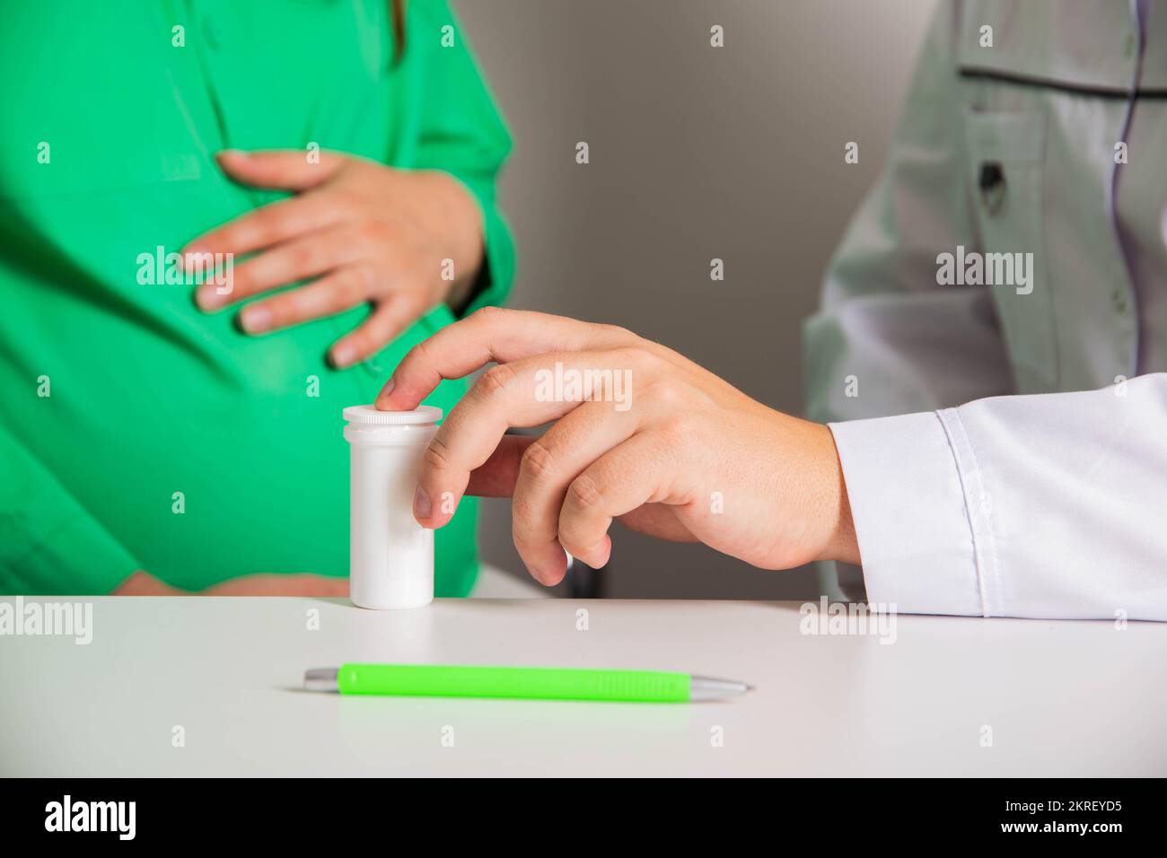 The doctor passes the medicine to the pregnant girl. The concept of ...