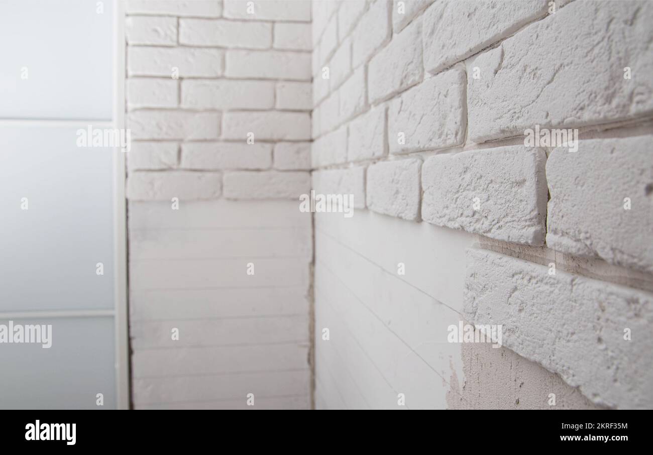 White wall made of decorative stone in the form of a brick. Laying ...