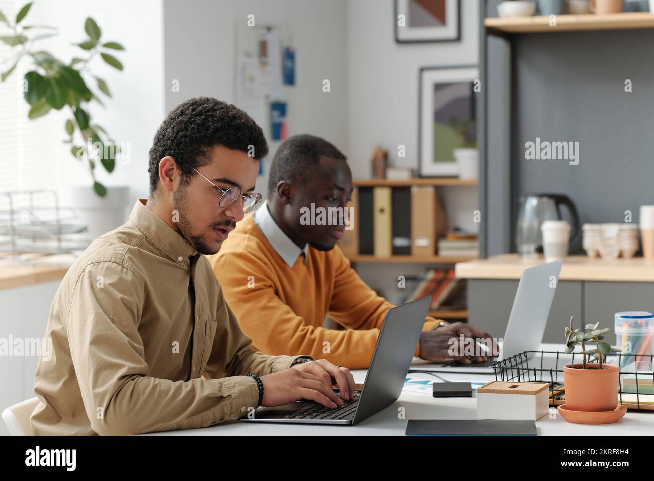 Young developers typing on computers at table, they working over new ...