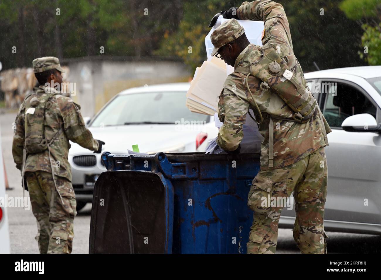 Trainees dump paper products into a bin for shredding, Nov. 15, during ...