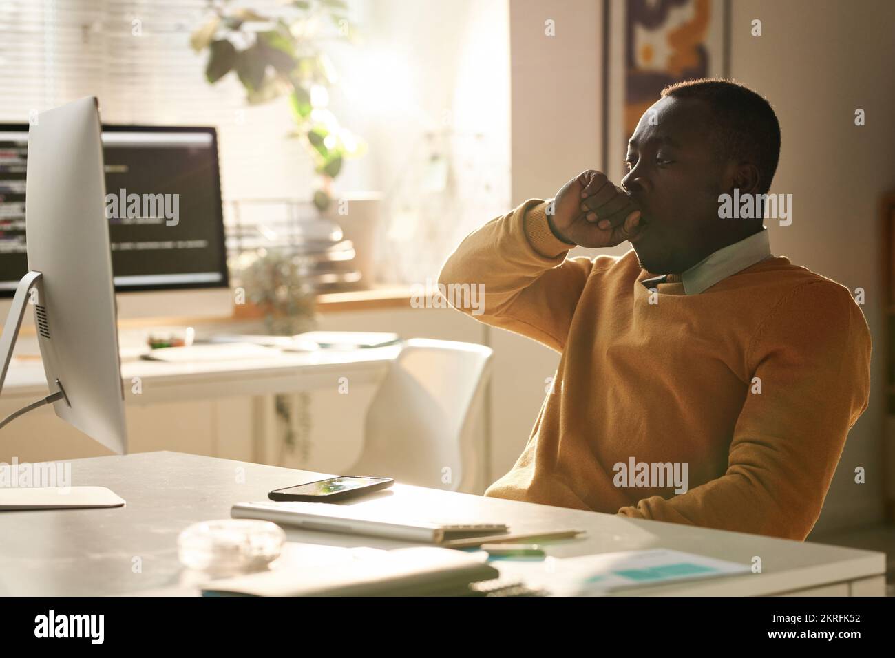 African American IT developer tired of work on computer, he sitting at ...