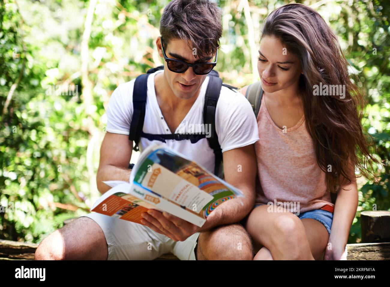 What trail do you suggest. a young couple looking at a guidebook while ...