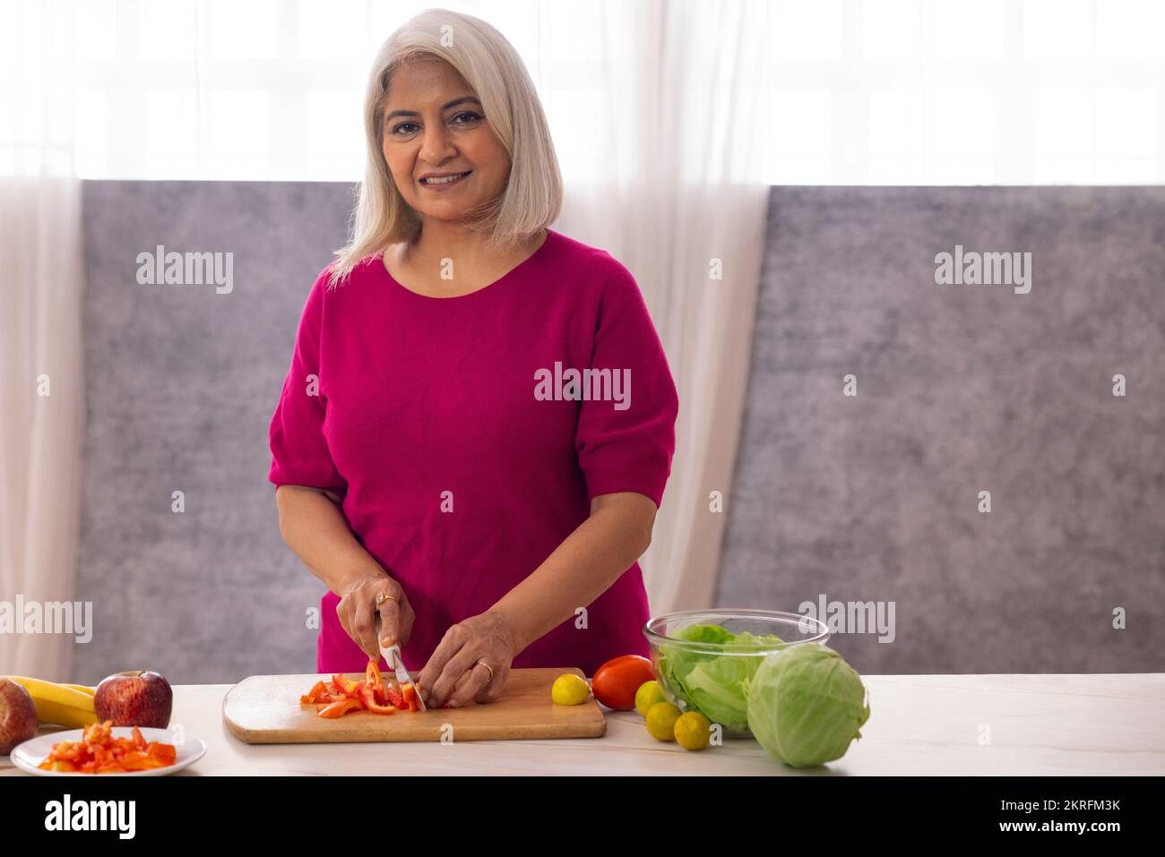 Old woman chopping vegetables in the kitchen Stock Photo - Alamy