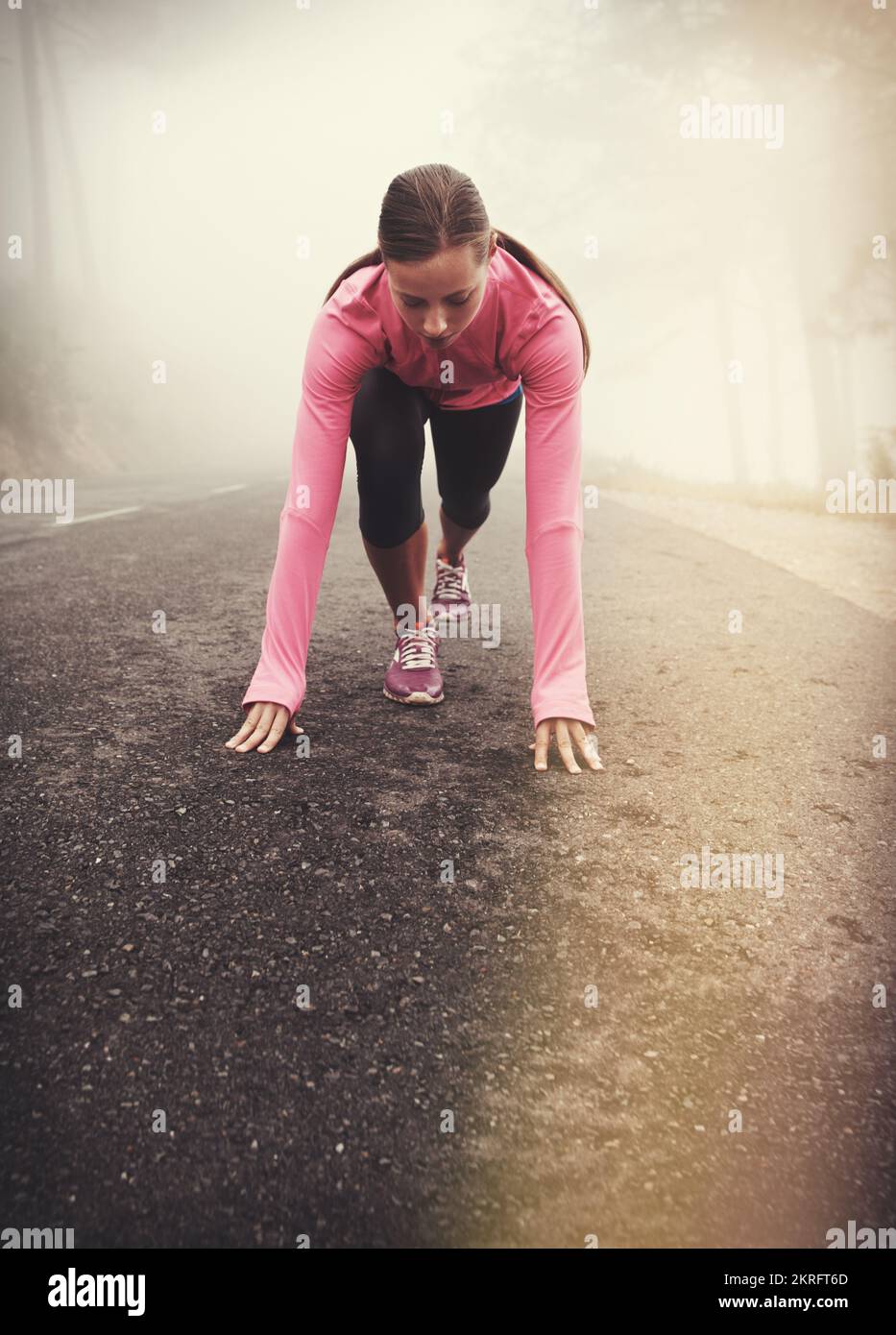 Getting focused for the run ahead. a young female runner about to start ...