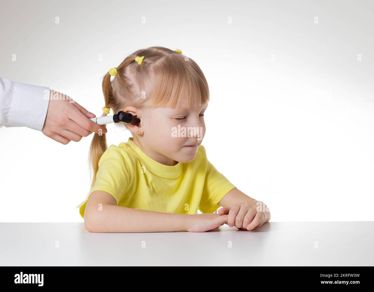 An otolaryngologist examines the ear of a child girl at the age of 5 ...