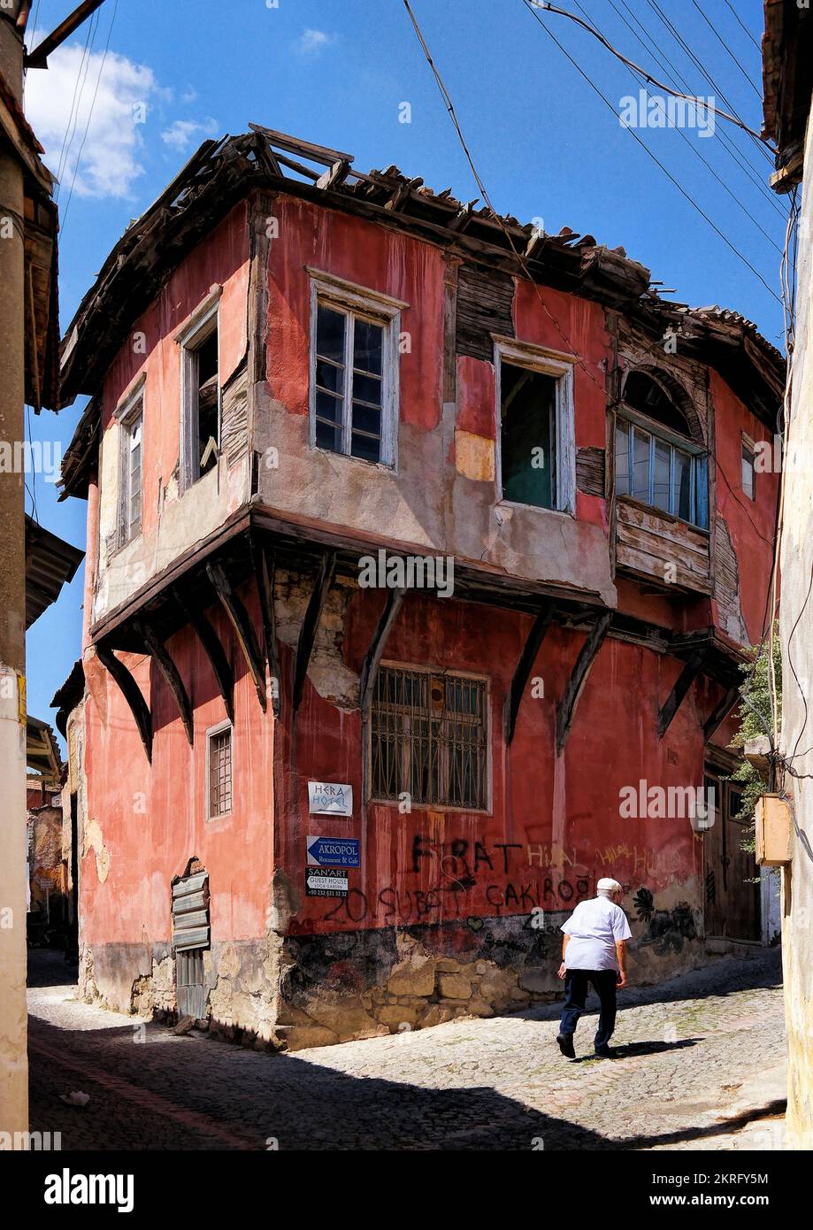 Bergama, Turkey, Sep.2018: An old man walking in a street with red ...