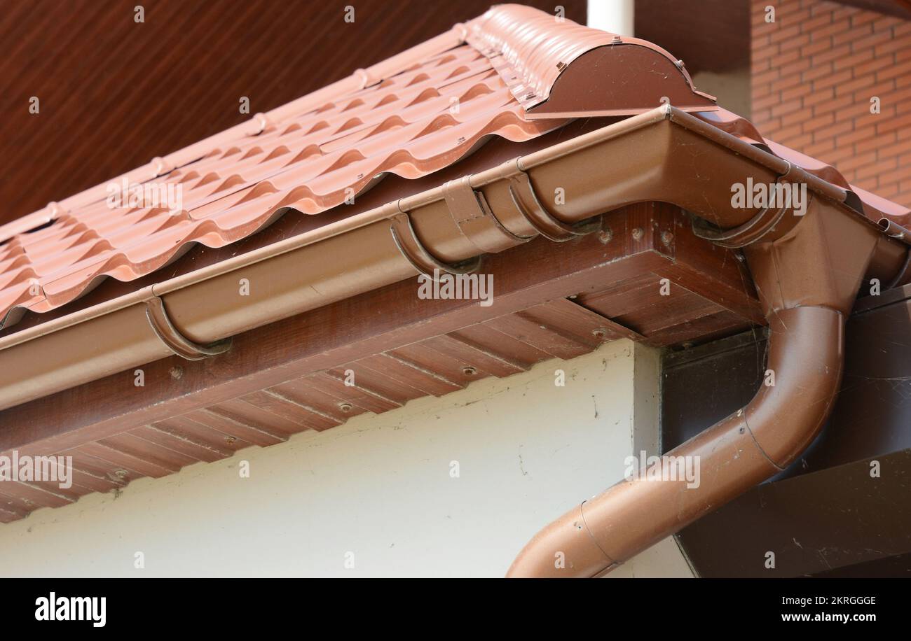 House metal rooftop with plastic rain gutter pipeline, soffit and soffit boards. Guttering house ...