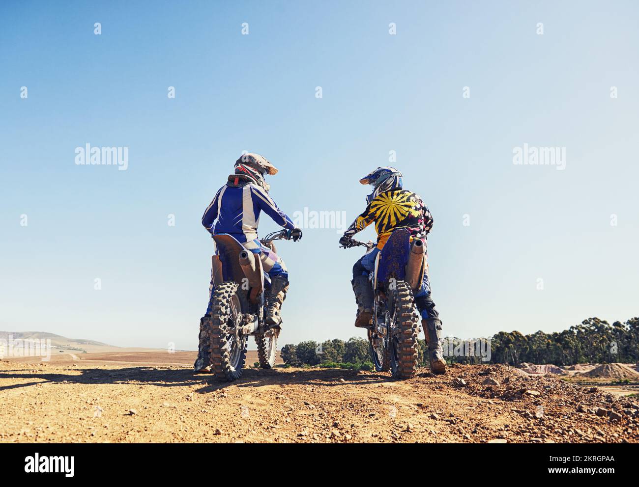 Time to rip up this track. Two motocross riders talking before a race ...