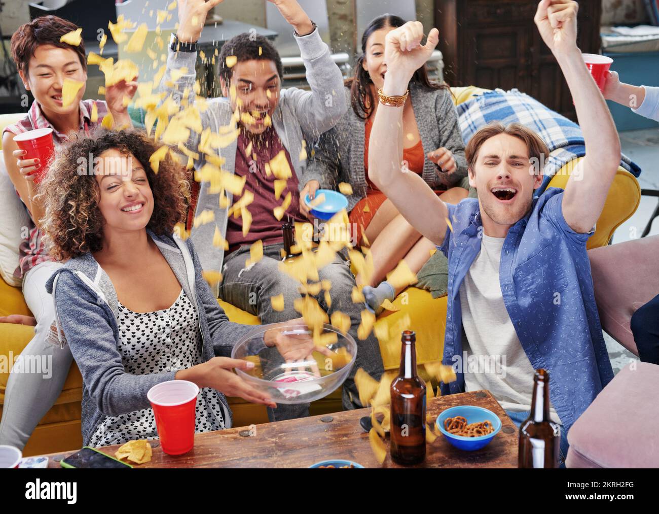 Sports, fan and friends watching tv with food, chips and snacks in ...