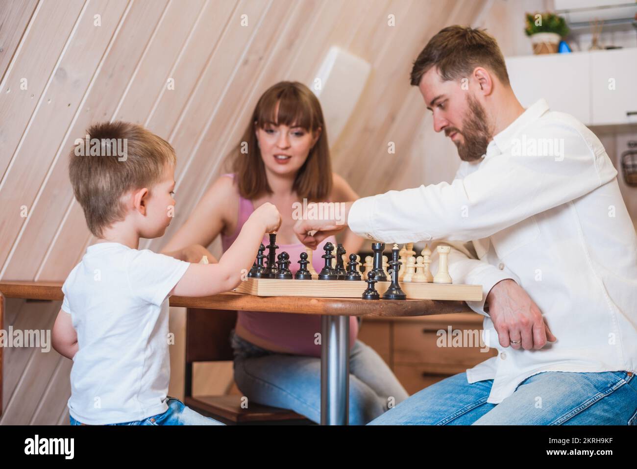Happy family playing chess in the room Stock Photo - Alamy