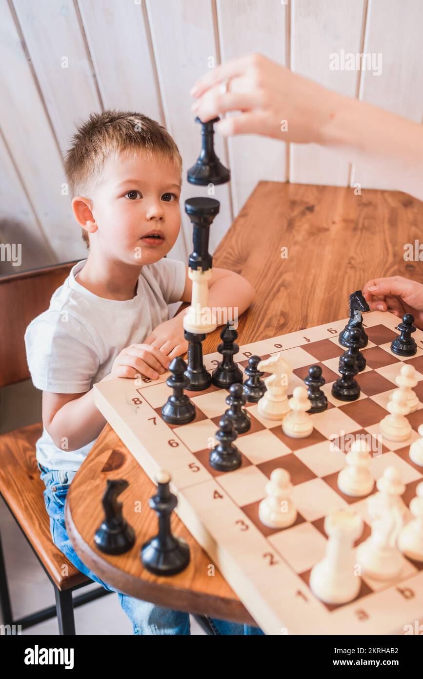 Boy playing chess at home at the table Stock Photo - Alamy