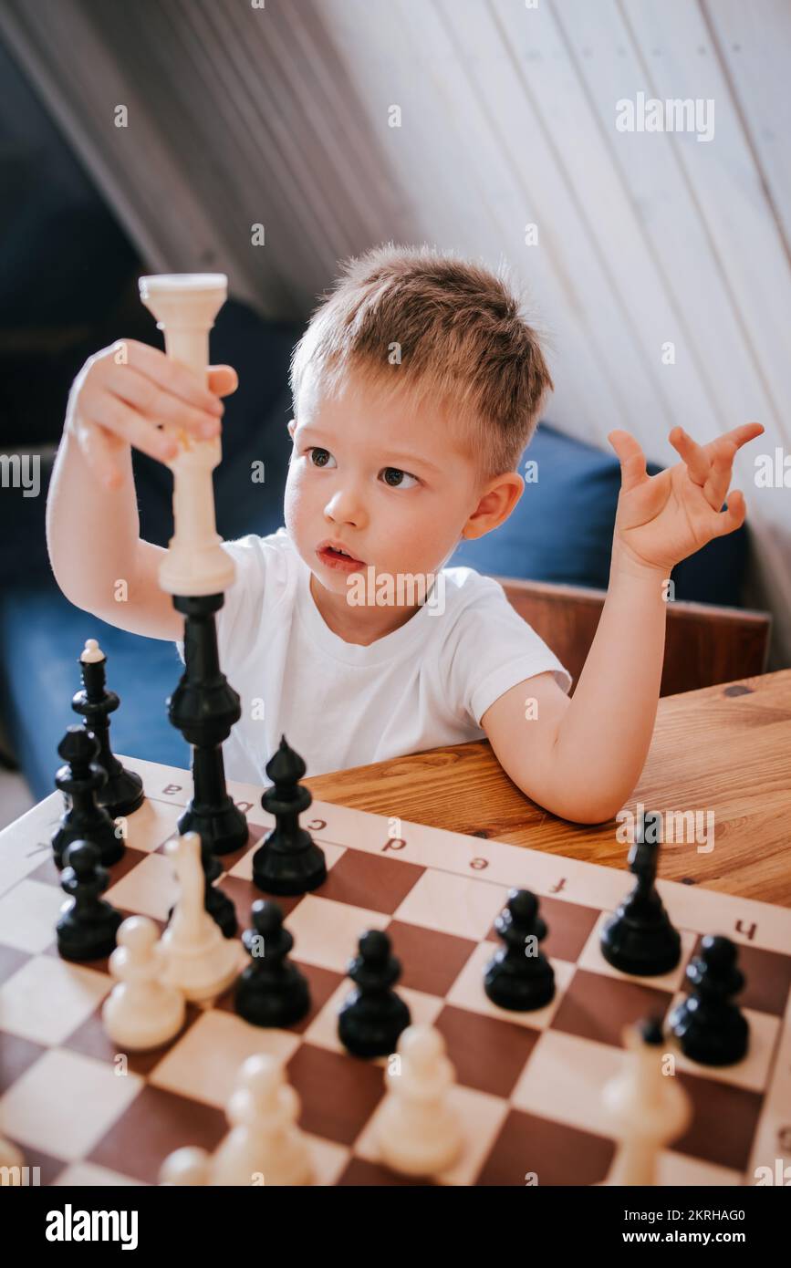Boy playing chess at home at the table Stock Photo - Alamy