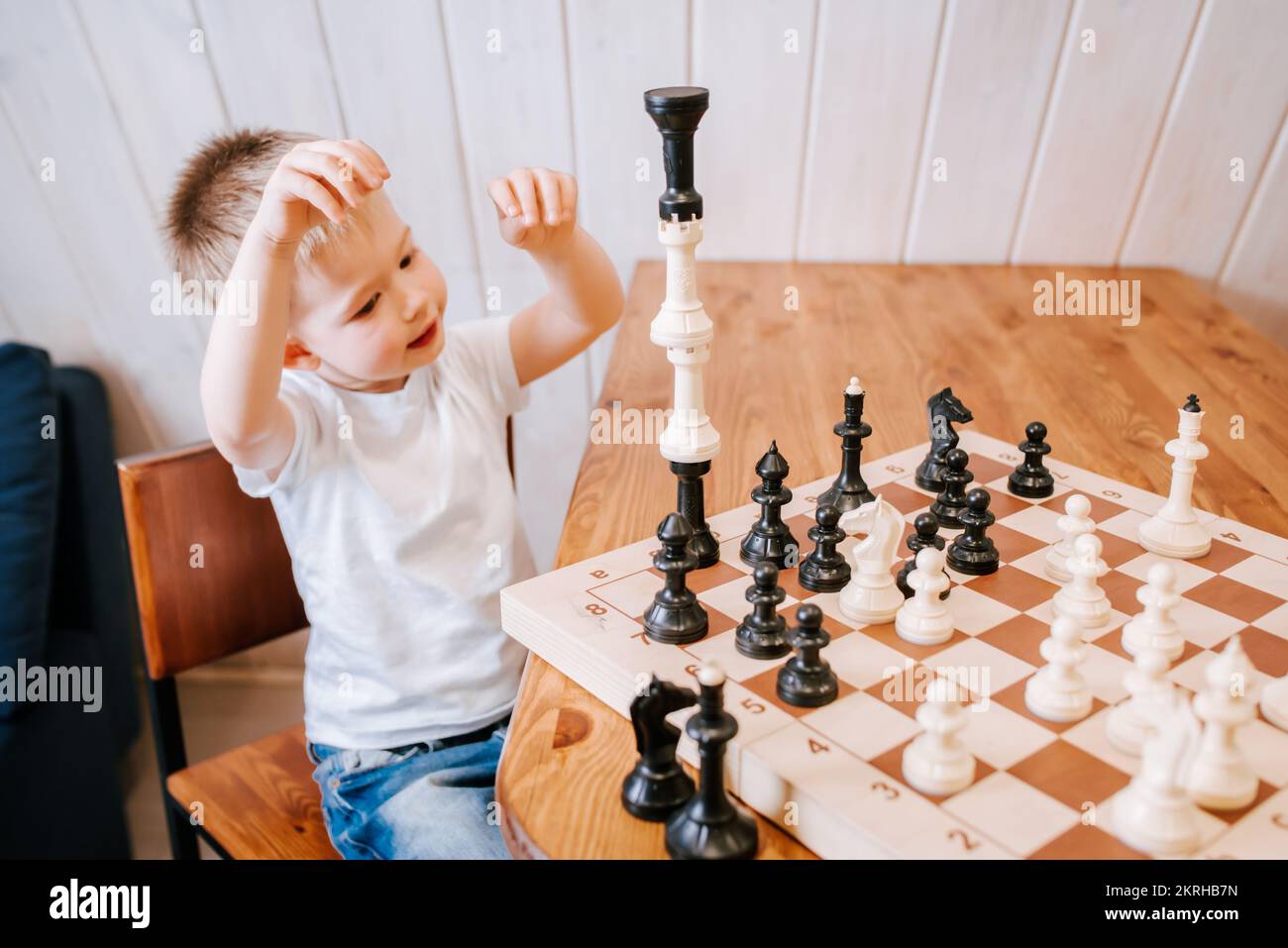 Cute child playing chess at home at the table Stock Photo - Alamy
