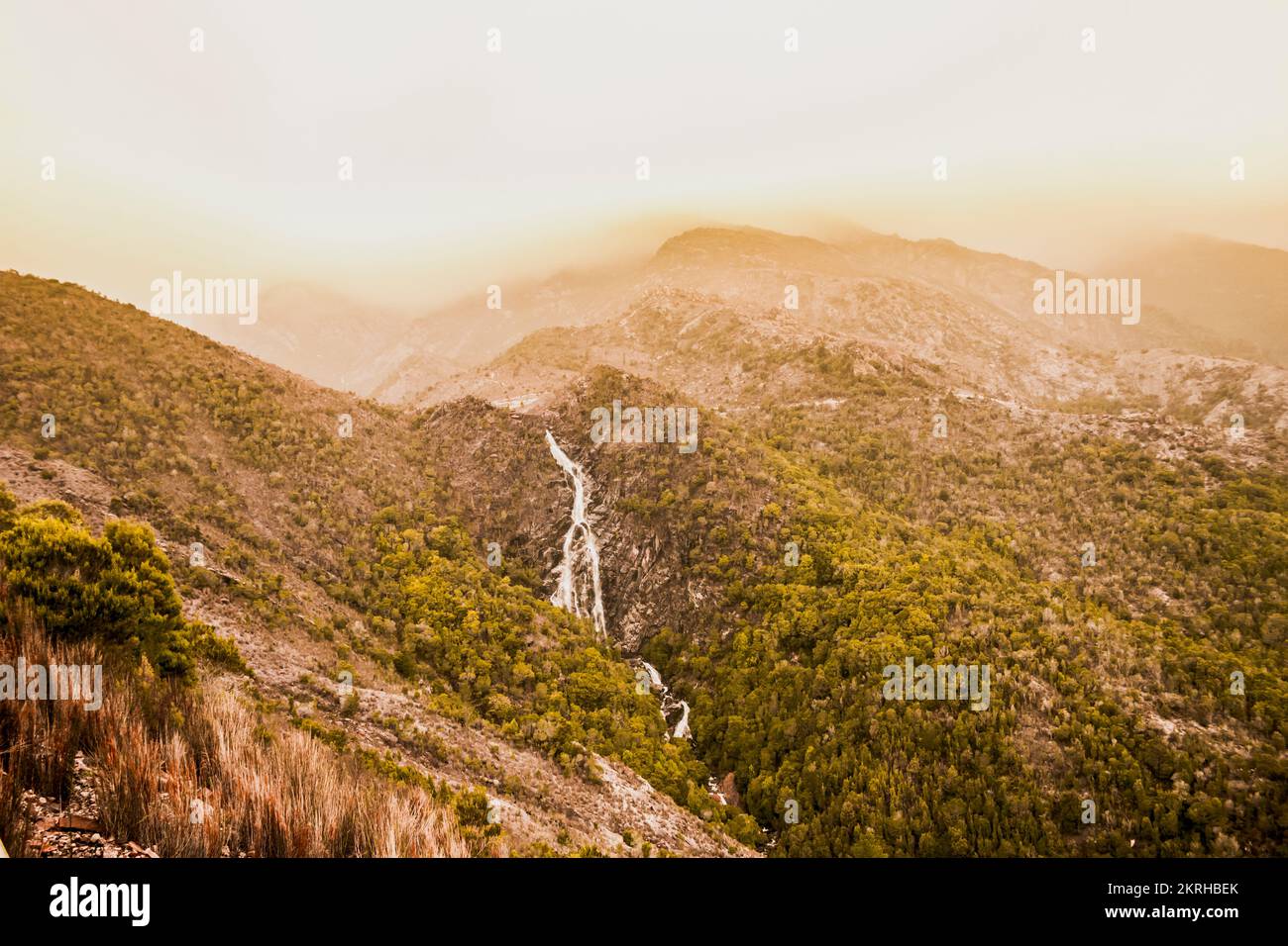 Landscape art on a rugged river waterfall flowing from the face of a ...