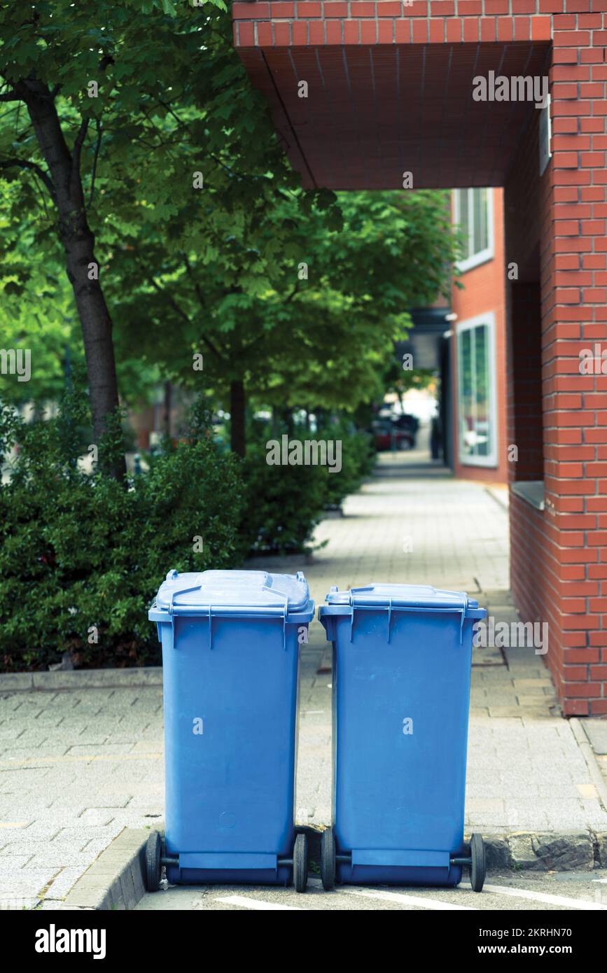 Blue garbage bin near a city house Stock Photo - Alamy