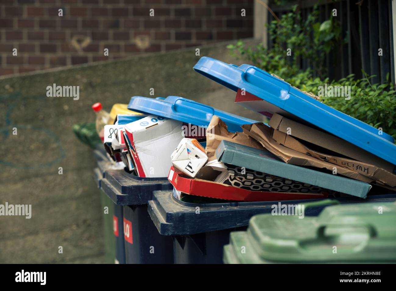 Trash bin overflowed with carton Stock Photo - Alamy