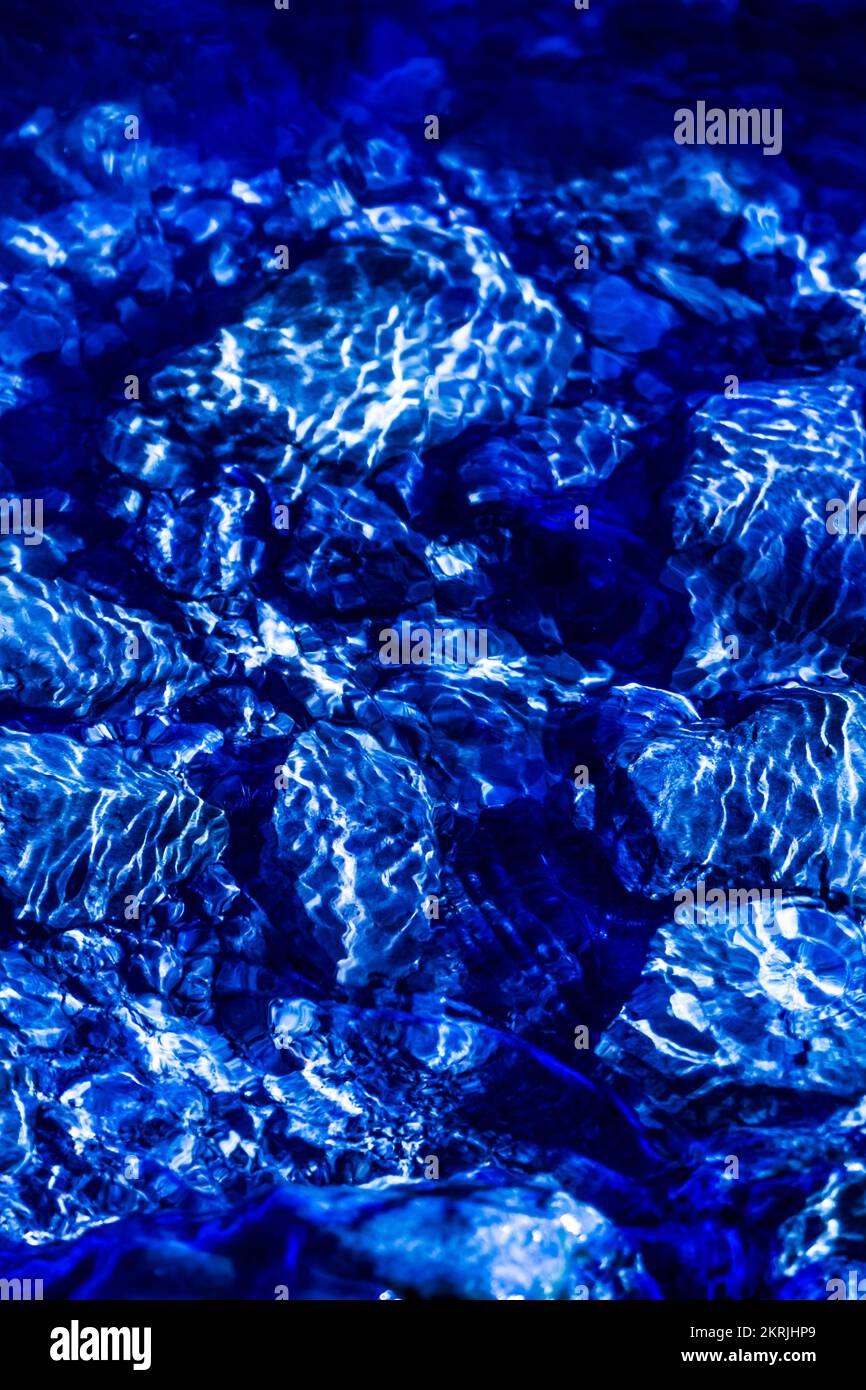 Detailed nature photo on rocky water shallows with light and ripples ...