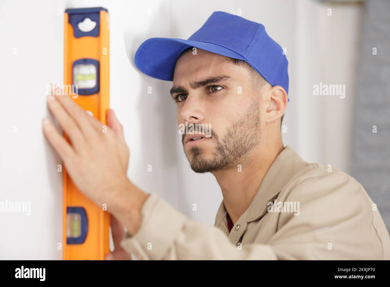 young building holding spirit level against interior wall Stock Photo ...