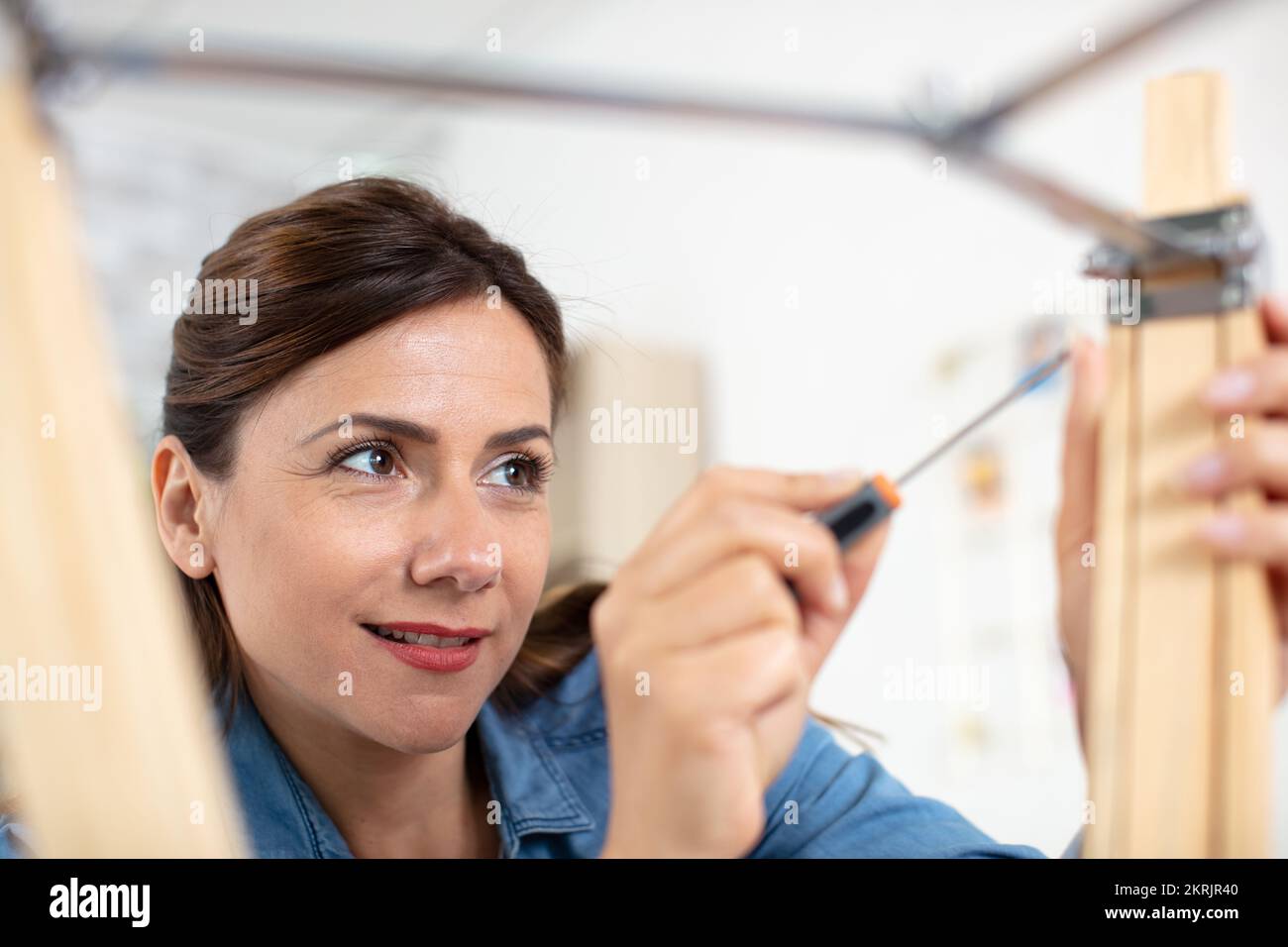 woman assembling wooden furniture using hex key Stock Photo - Alamy