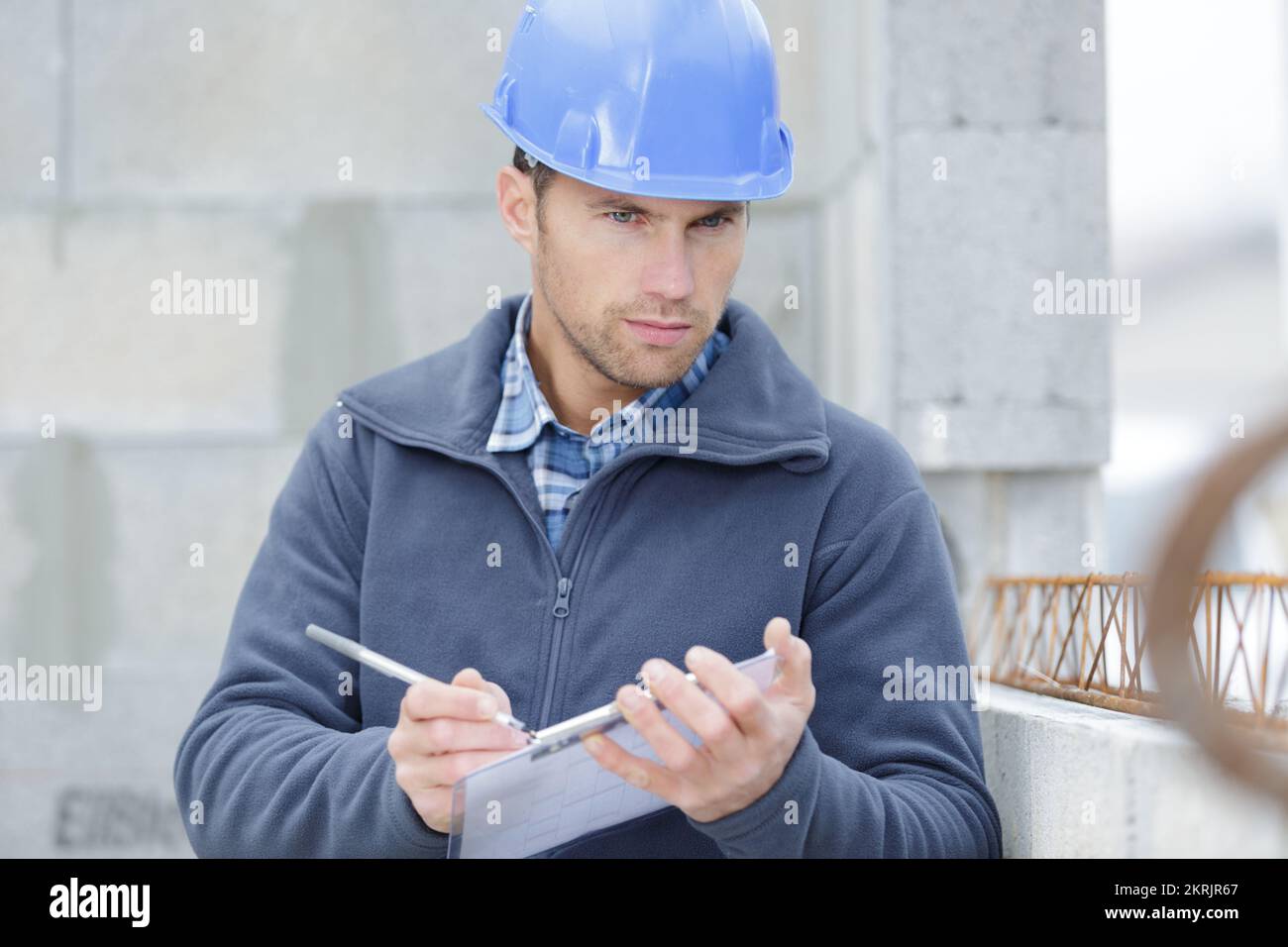 handsome foreman making notes on a clipboard Stock Photo - Alamy
