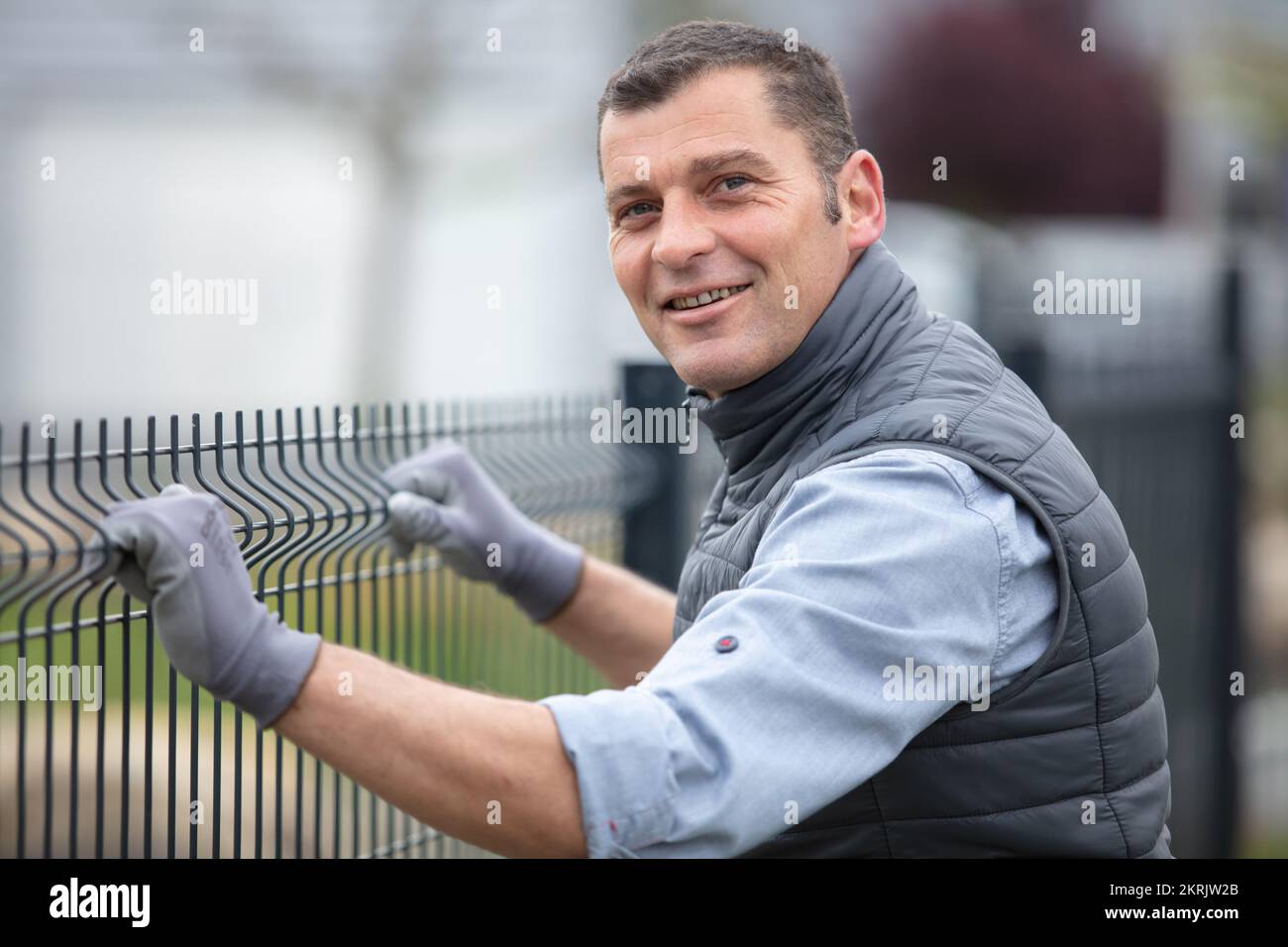 worker is fitting a fence Stock Photo - Alamy