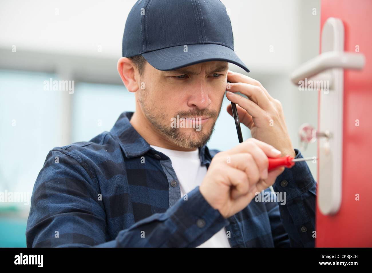 Happy handyman fixing door hi-res stock photography and images - Alamy