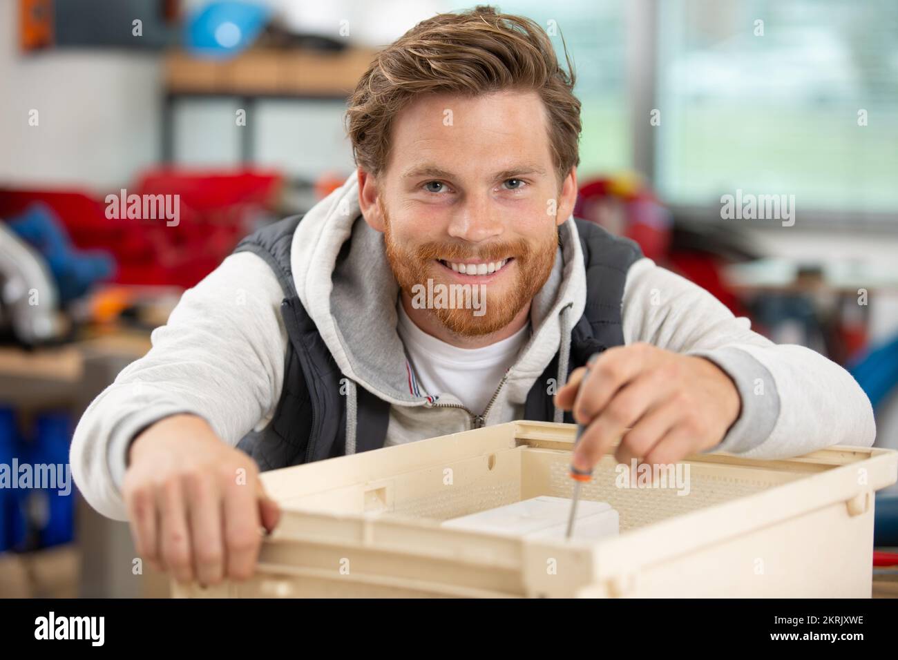happy man putting together self assembly furniture Stock Photo - Alamy