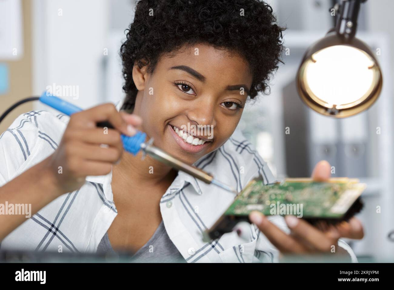 female technician using soldering iron on computer hardware Stock Photo ...