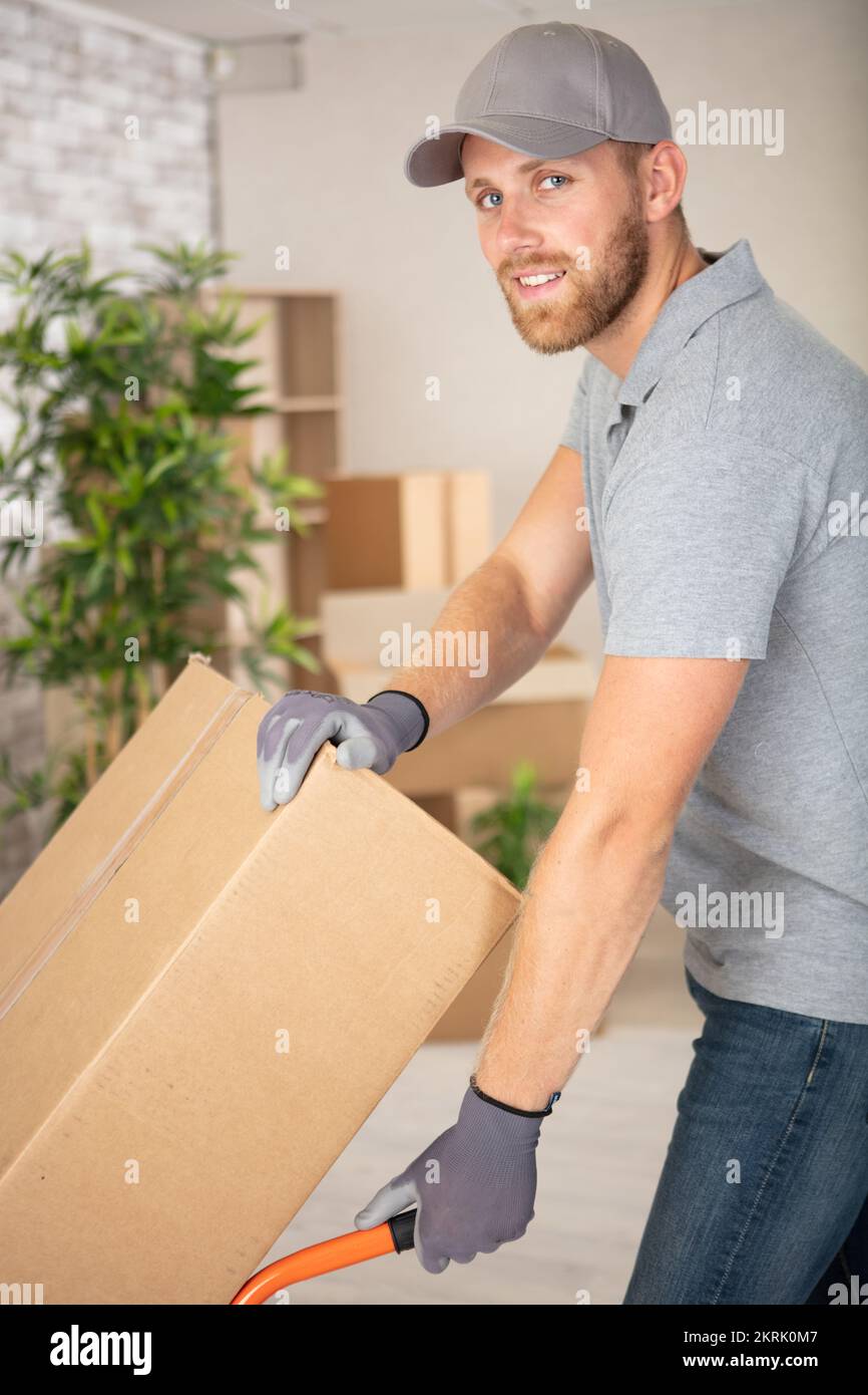 delivery man uses trolley full of cardboard boxes Stock Photo - Alamy