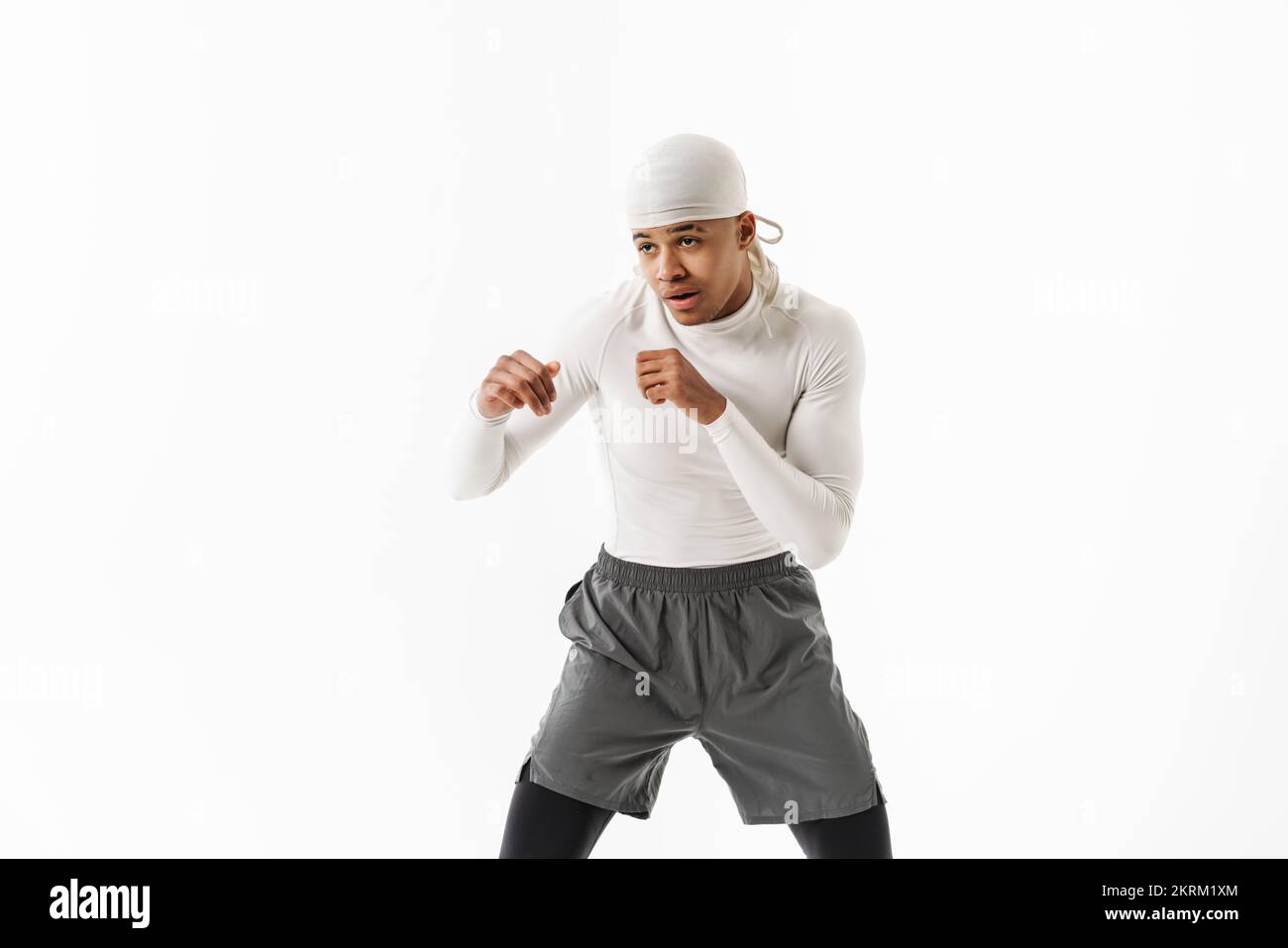 Young sportsman wearing bandana boxing while working out isolated over ...